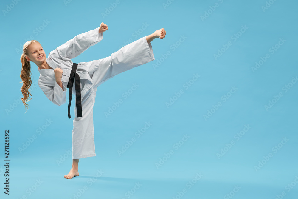 Positiive karate girl practicing kick foot forward. Stock Photo | Adobe ...