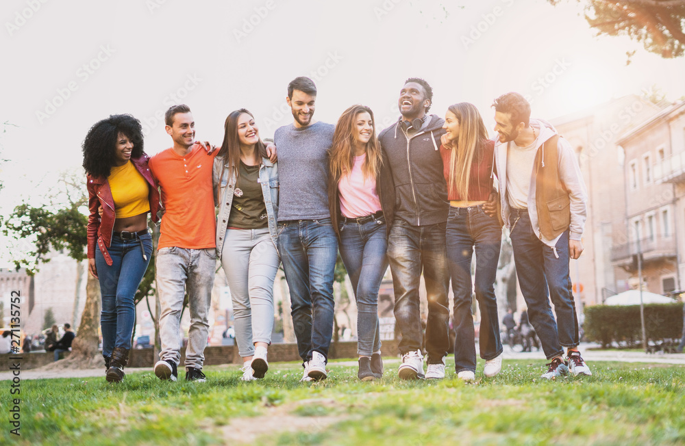 Mixed race group of friends having fun walking outdoors hand on ...