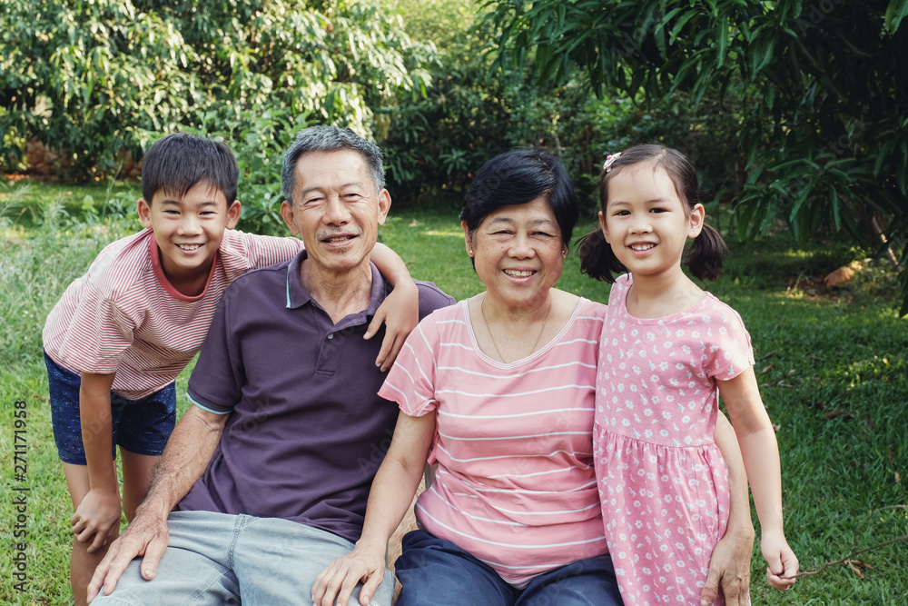Asian grandchildren laughing with their grandparents in the park, Happy ...