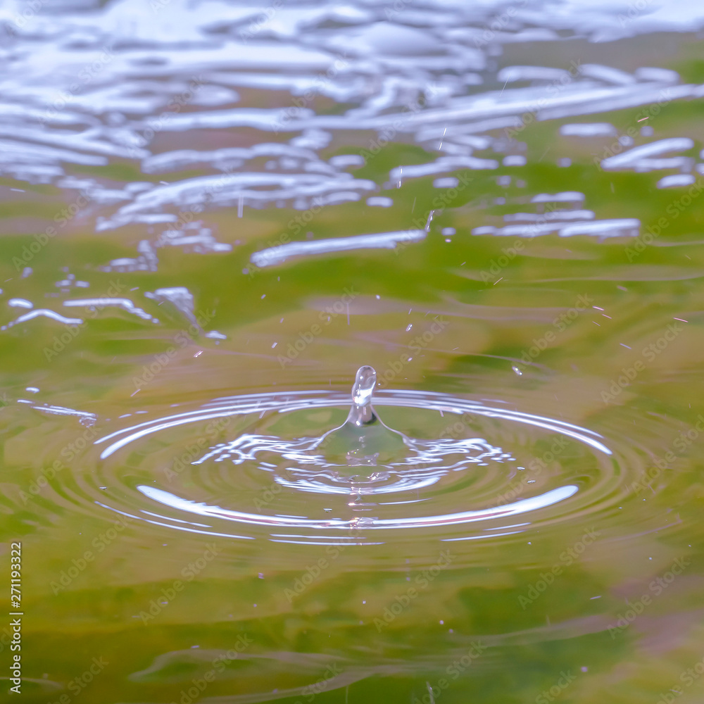 Square frame Stone dropped in water creating a splash and ripple on the ...