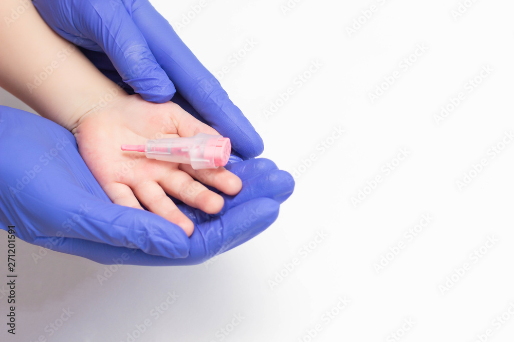 the doctor holds the hand of the child with a painless scarifier, the ...
