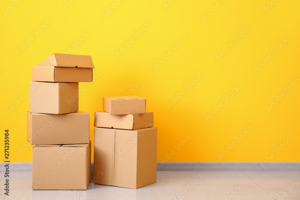 Cardboard boxes near color wall Stock Photo | Adobe Stock