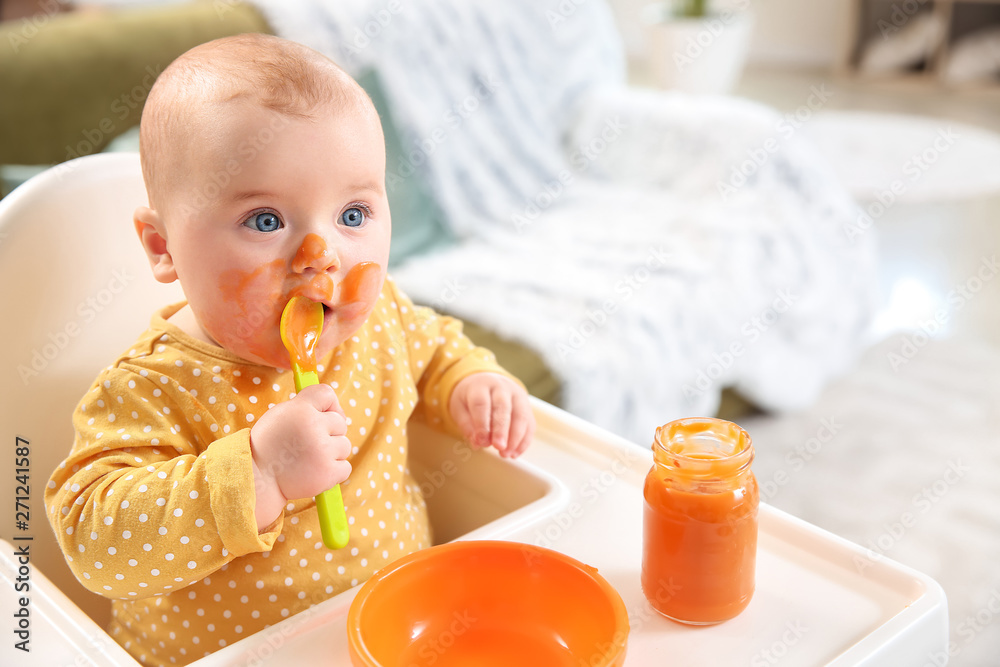 Cute little baby eating tasty food at home Stock Photo | Adobe Stock