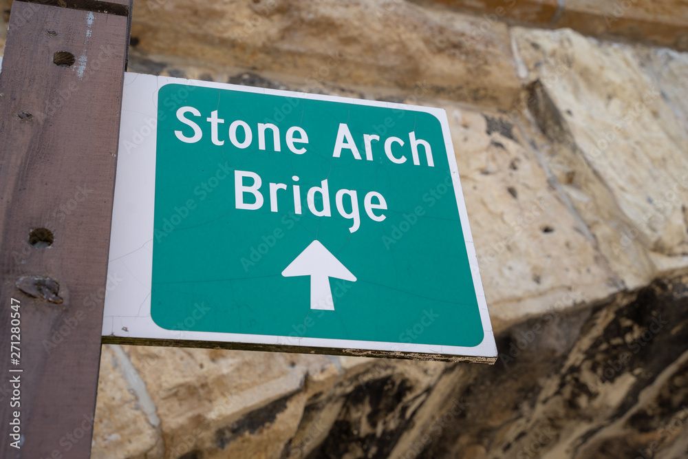 Sign guiding visitors directions to the iconic Stone Arch Bridge in ...