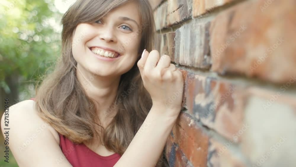 Cute Funny Girl Bangs Her Fist On A Red Brick Wall Communication With
