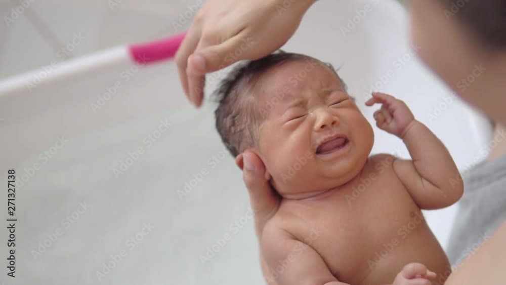 Adorable asian newborn baby girl is washing hair and taking bath by her ...