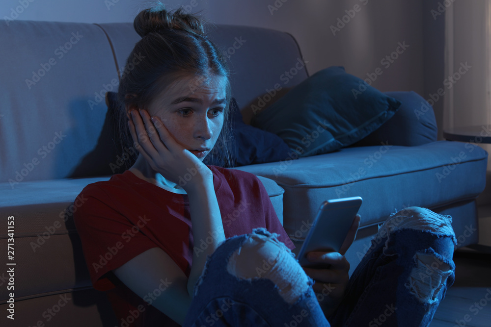 Shocked teenage girl with smartphone in dark room. Danger of internet ...
