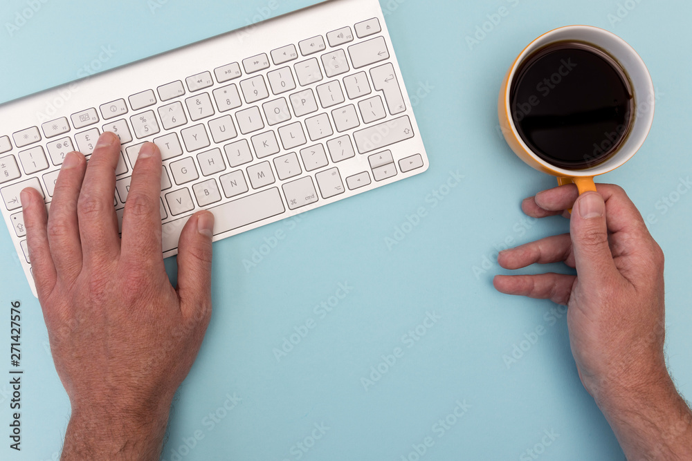 Man working on computer keyboard top view minimal office blue color ...