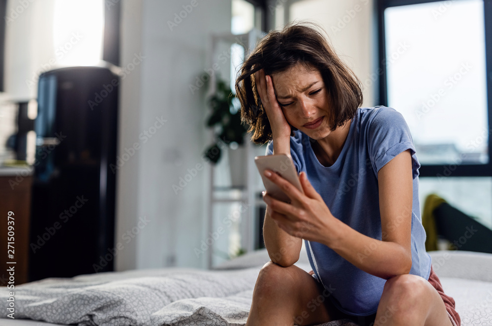 Young woman feeling disappointed while reading text message she ...