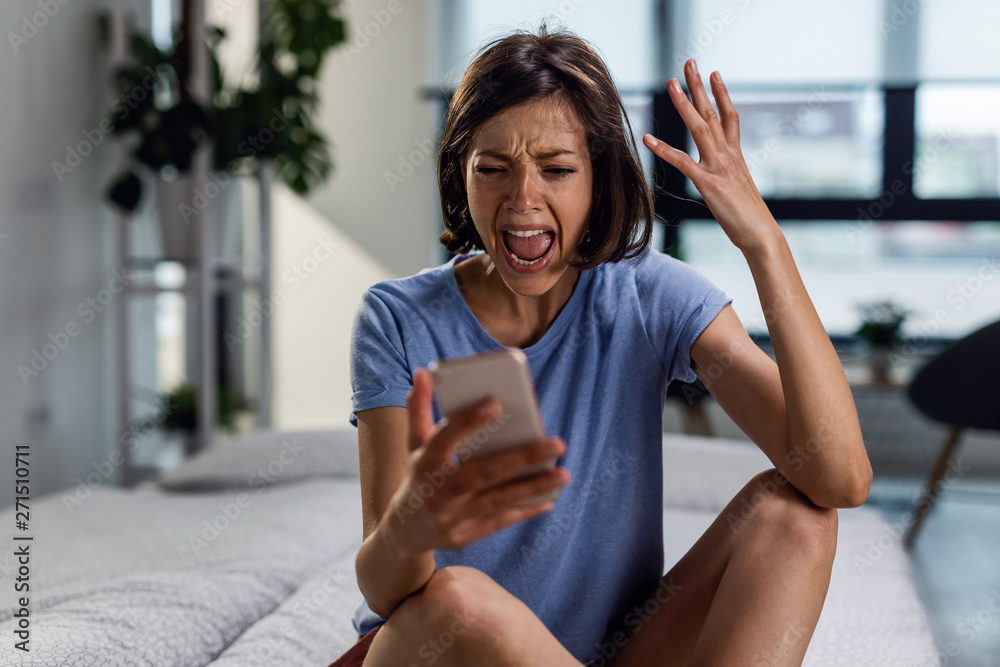 Angry woman screaming while reading text message on her phone. Stock ...