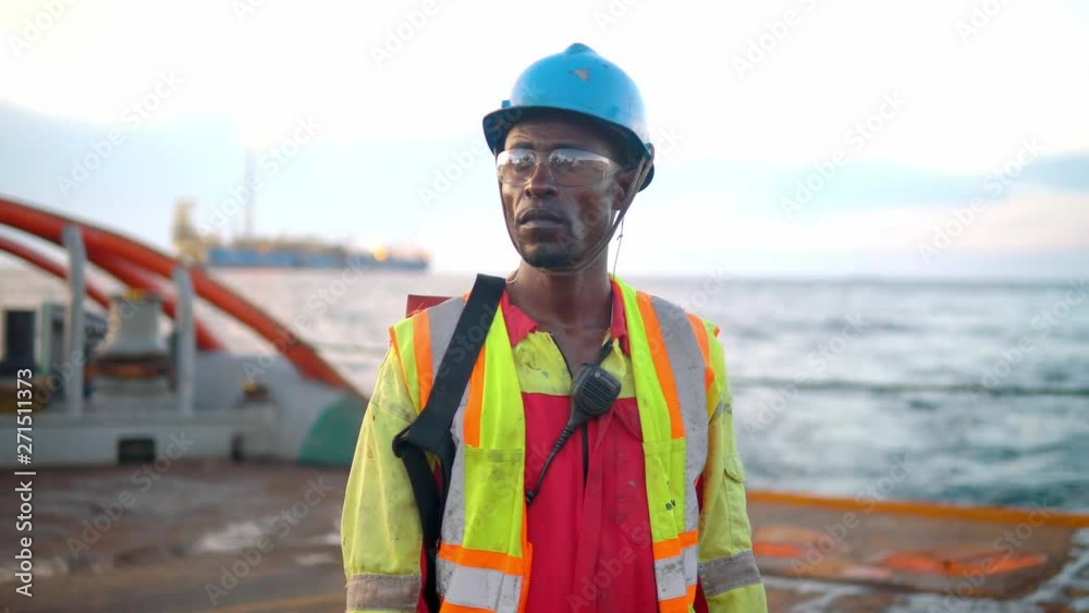 Seaman AB or Bosun on deck of vessel or ship , wearing PPE personal ...
