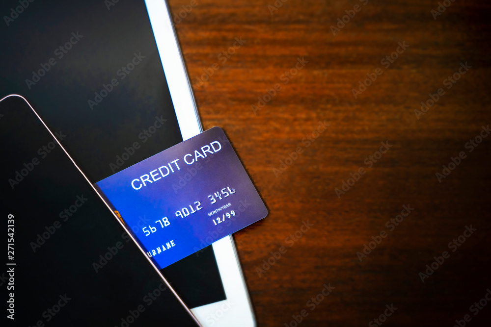 Credit card with mobile and tablet on wood table with free space for ...