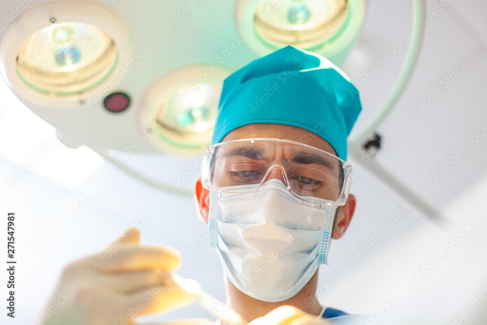 Beautiful portrait of a surgeon doctor at work. The lamp in the ...