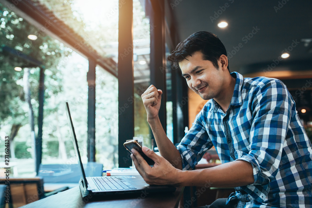Asian Young man delighted with the success of Online stock market ...
