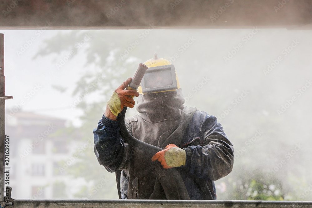 Sand blasting process Industial worker using sand blasting process ...