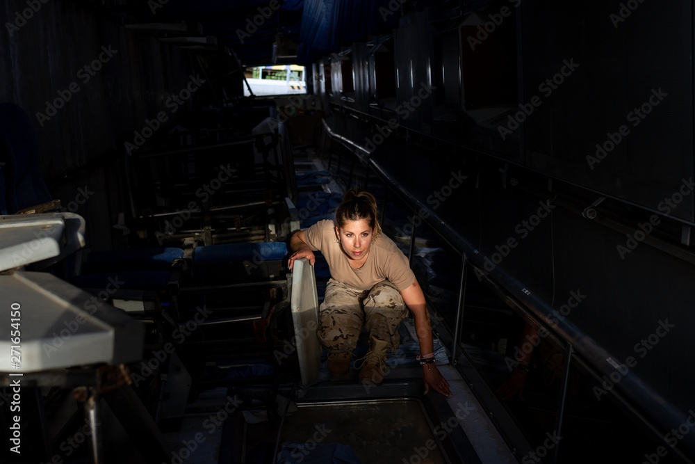 Side view of strong female soldier pointing up while looking at sky ...
