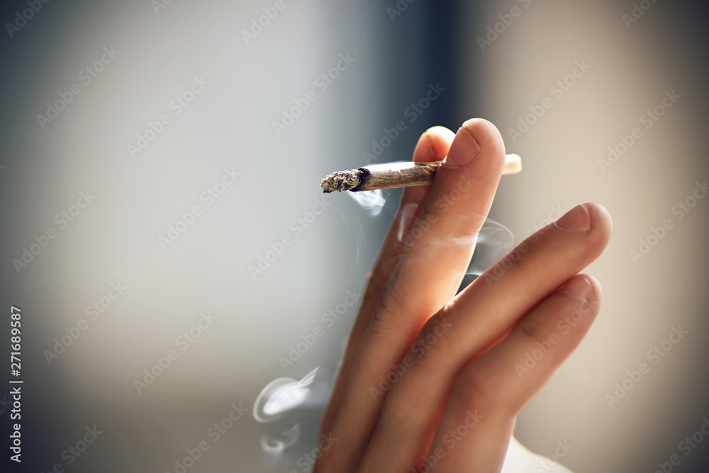 Human elegantly holds in the fingers of a hand Smoking a cigarette ...
