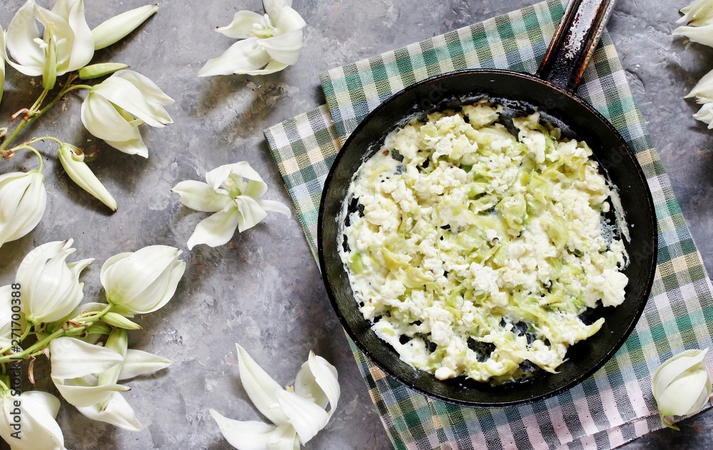 Fried yucca flower petals with eggs and tomatoes. national cuisine of ...