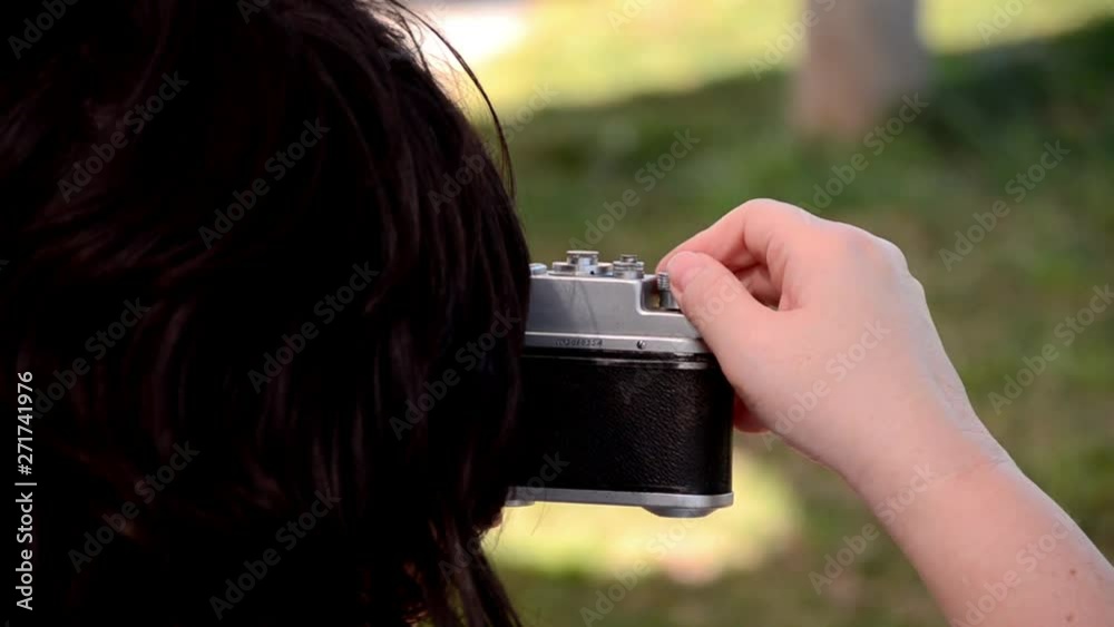 Back view of black hair woman taking pictures with an old camera. Big ...