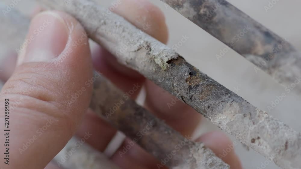 Burnt-out heating element from a washing machine. Man is touching ...