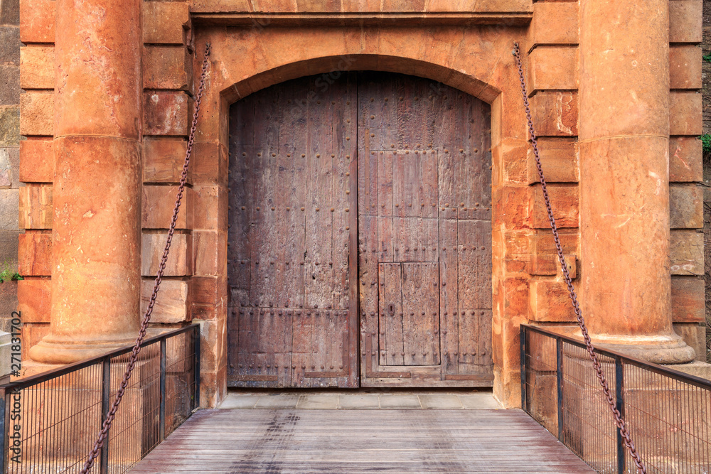 Wooden gate to a medieval castle surrounded by a moat and accessible by ...