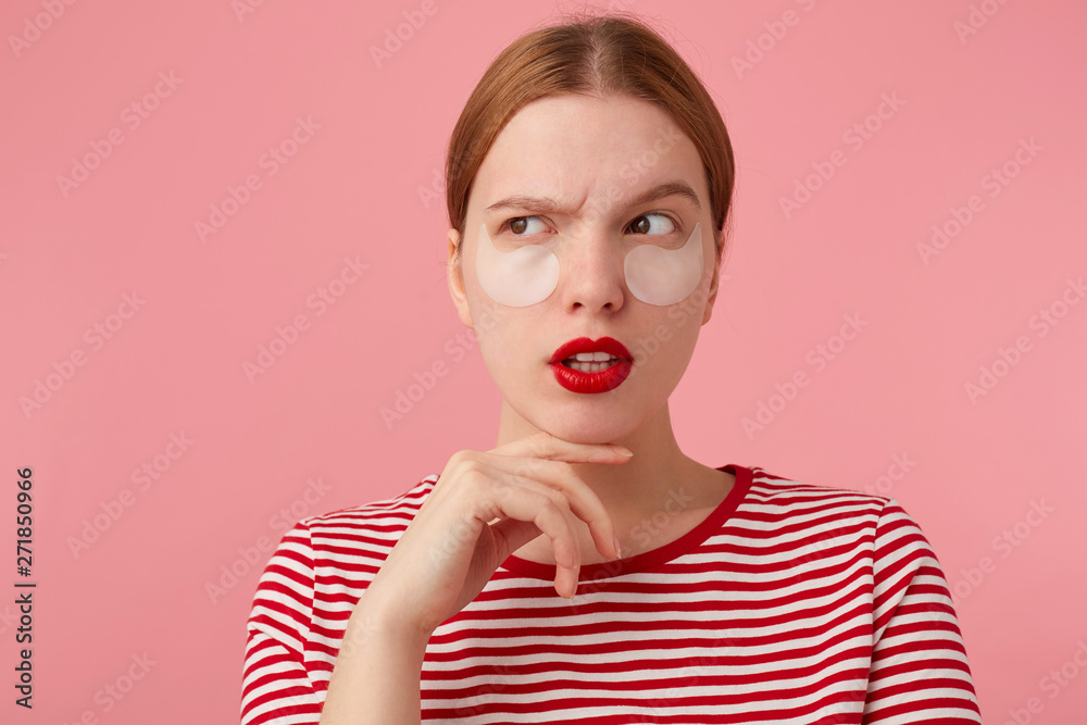 Cute thinking young red-haired girl with red lips and with patches ...