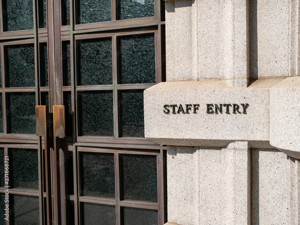 Staff entry sign outside of office building next to double doors Stock ...