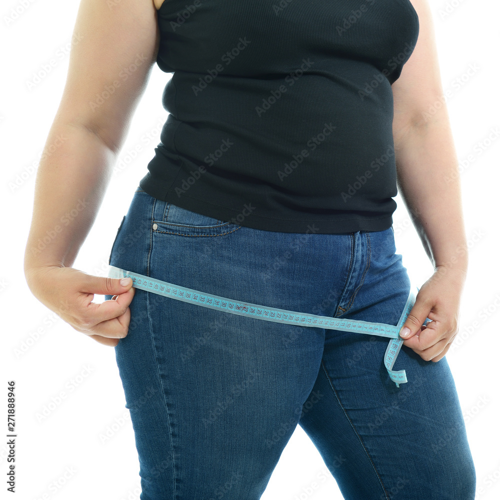 Overweight unhappy young woman measuring her hips, isolated over white ...