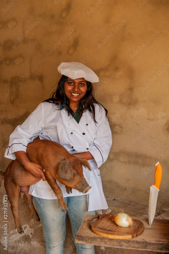 Attractive Indian woman cook posing with red pig. Closeup portrait of ...