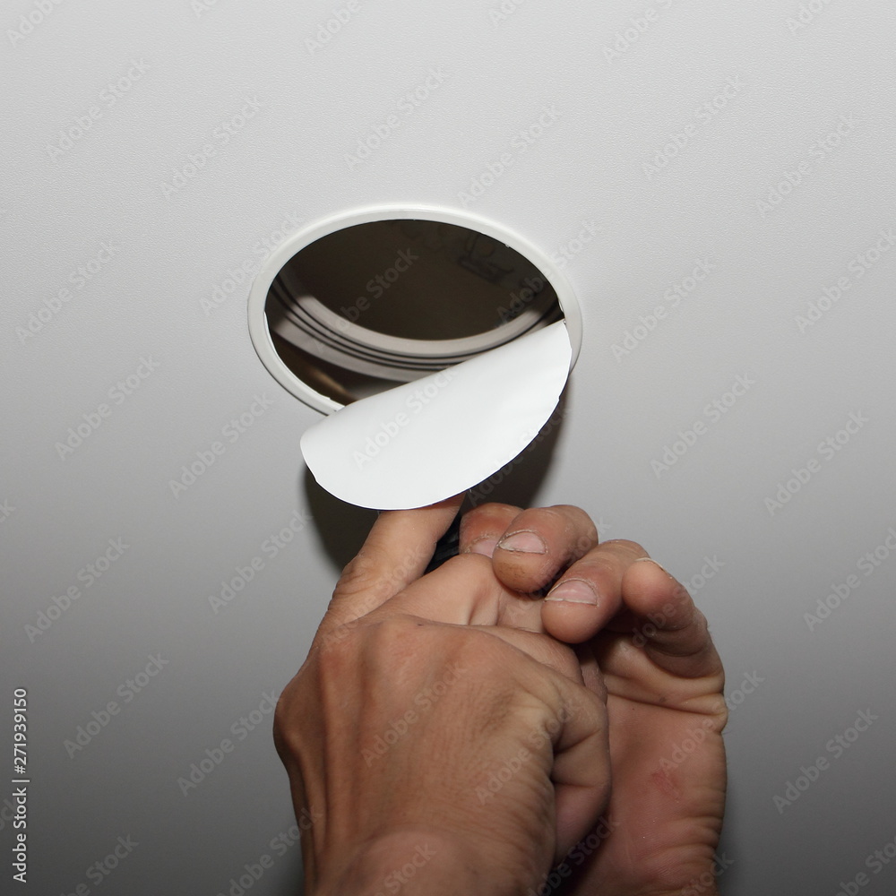 Cutting a hole for the recessed spot light in the suspended ceiling ...