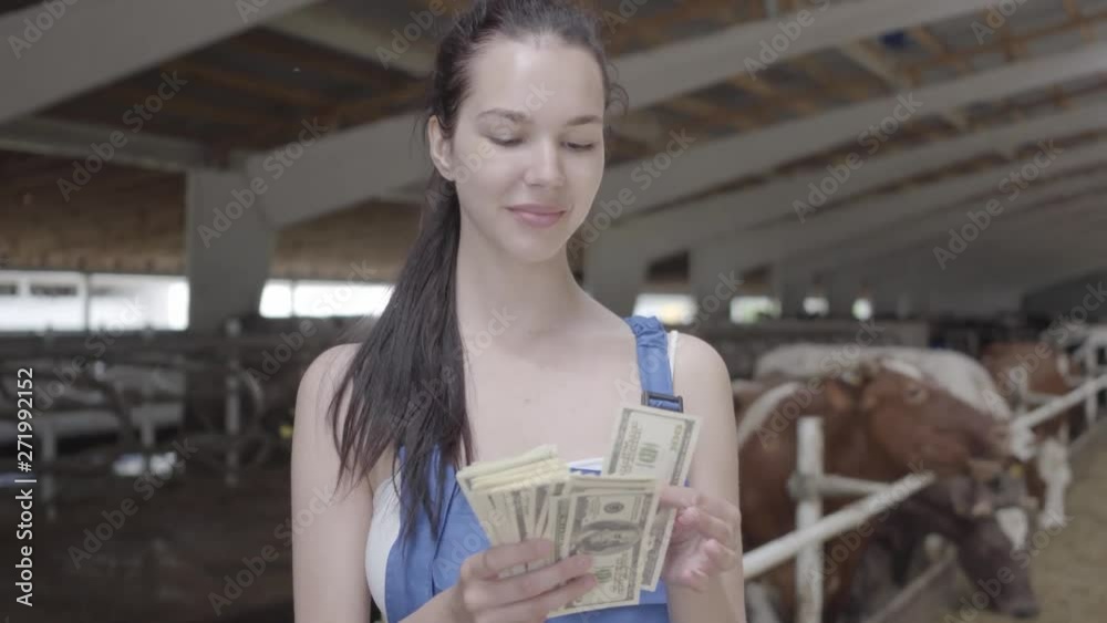 Portrait cute female farmer worker on the cow farm counting cash ...