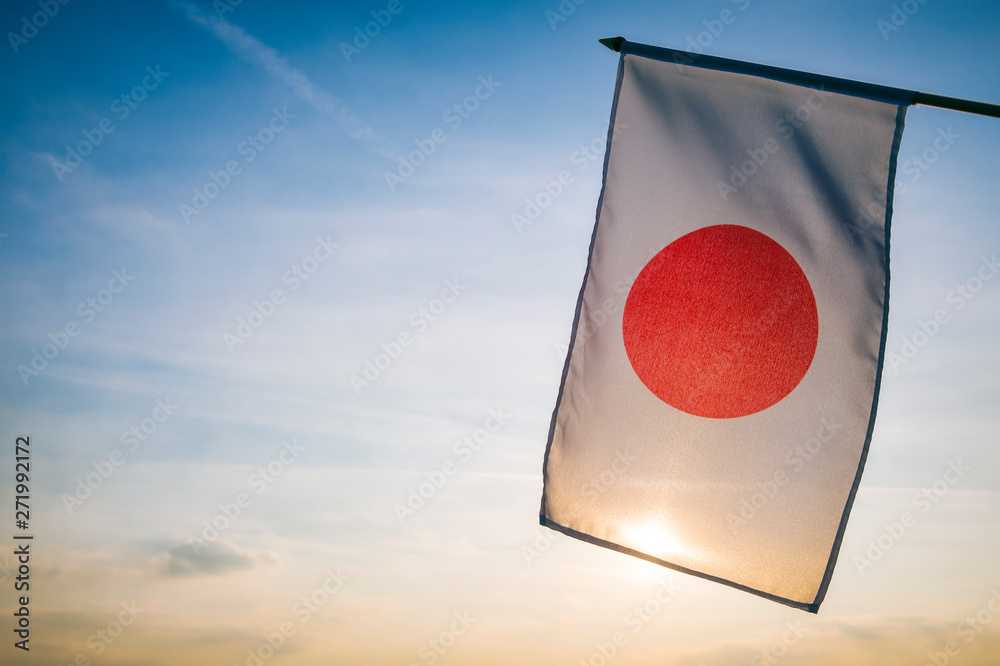 Japanese flag hanging outdoors in the still golden light of the rising ...