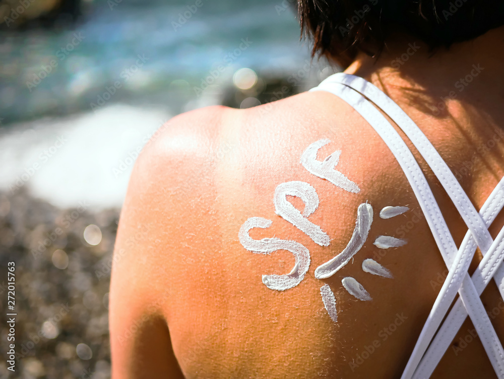 SPF shaped cream on the shoulder of young girl like a sign of protect ...