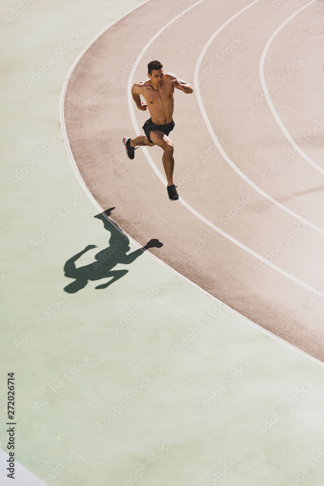 Shirtless athlete running on track Stock Photo | Adobe Stock