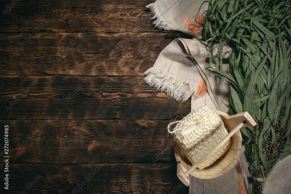 Eucalyptus bath broom, water bucket and a towel on a bathhouse table ...