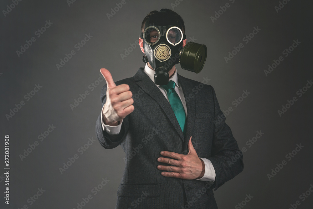 Man in a suit and a gas mask is showing a thumbs up by his hand on a ...