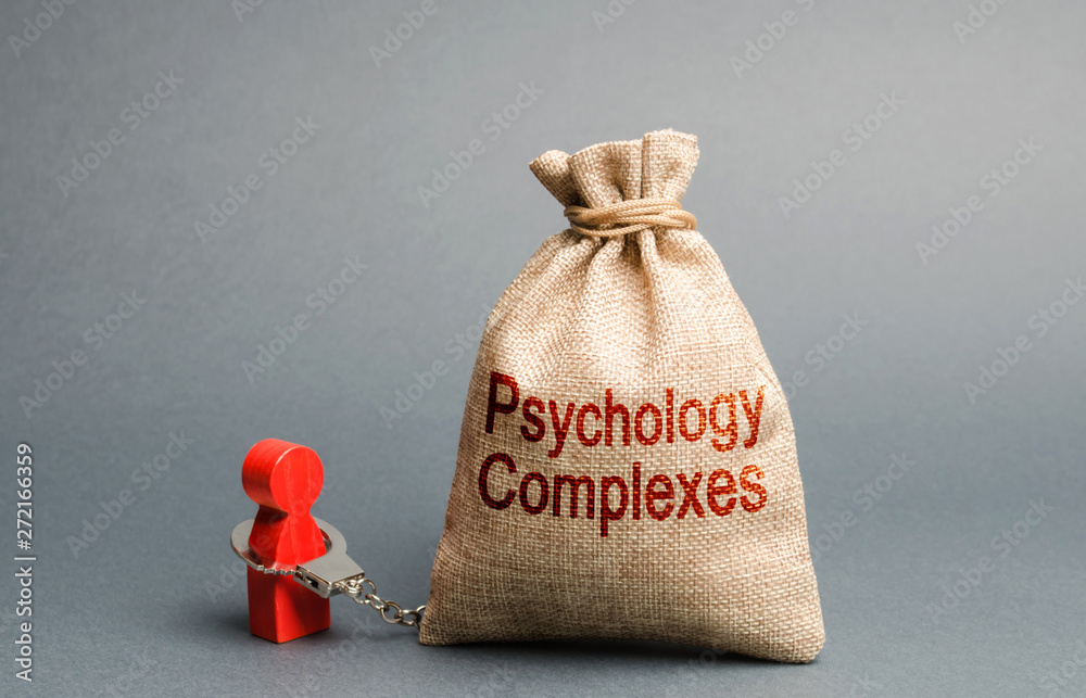 A person is handcuffed with a bag labeled psychological complexes ...