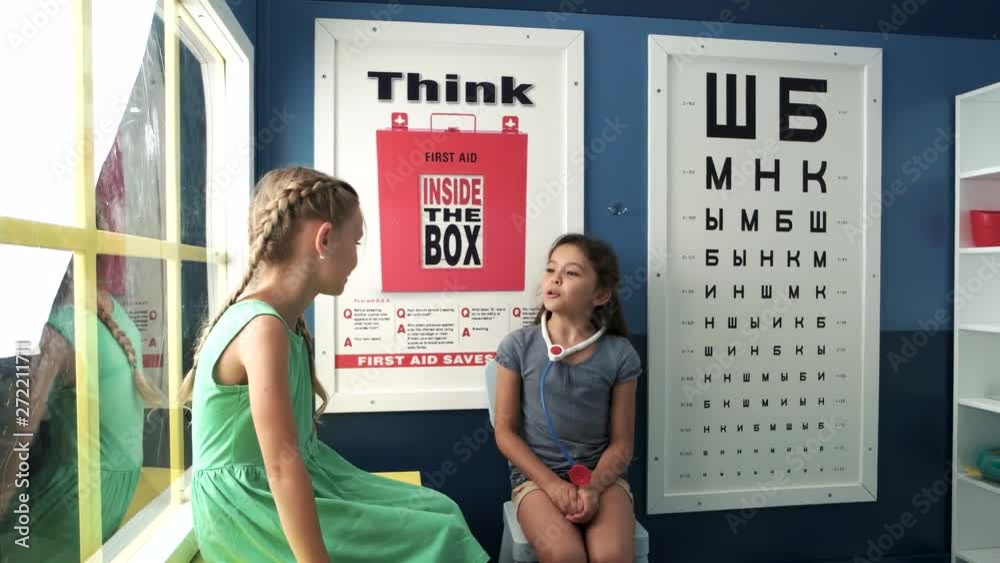 Beautiful girl playing oculist at medical office. Two little girls ...