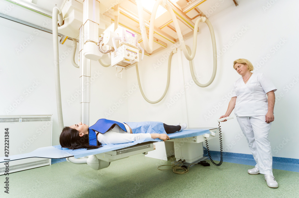 Radiologist and patient in a x-ray room. Classic ceiling-mounted x-ray ...