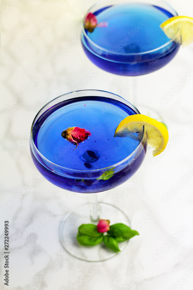 Thai asian blue Anchan tea in cocktail glasses with dry rosebuds ...
