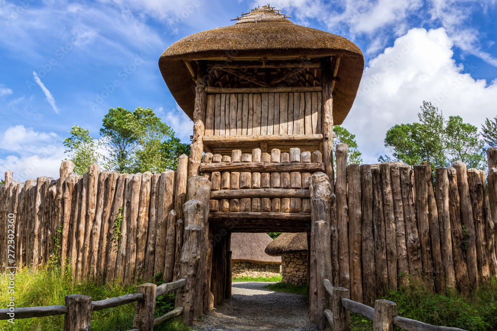 Entrance trough gate in palisade and guard tower to old thatch and ...