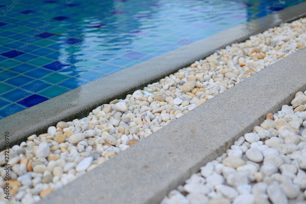 swimming pool grating covered with round white river pebble. drainage ...