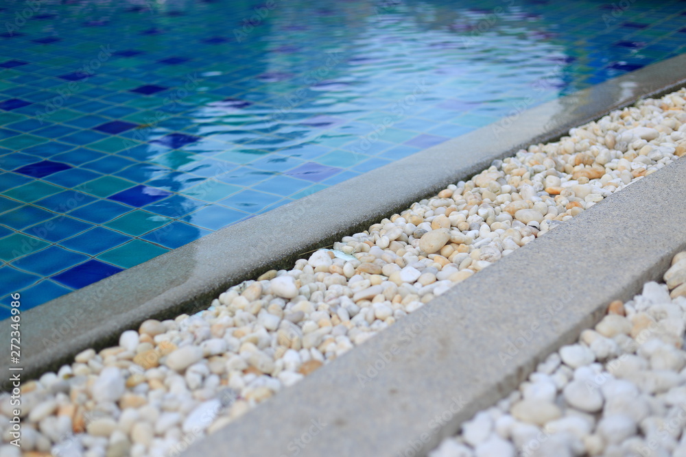 swimming pool drainage system grating covered with round white river ...