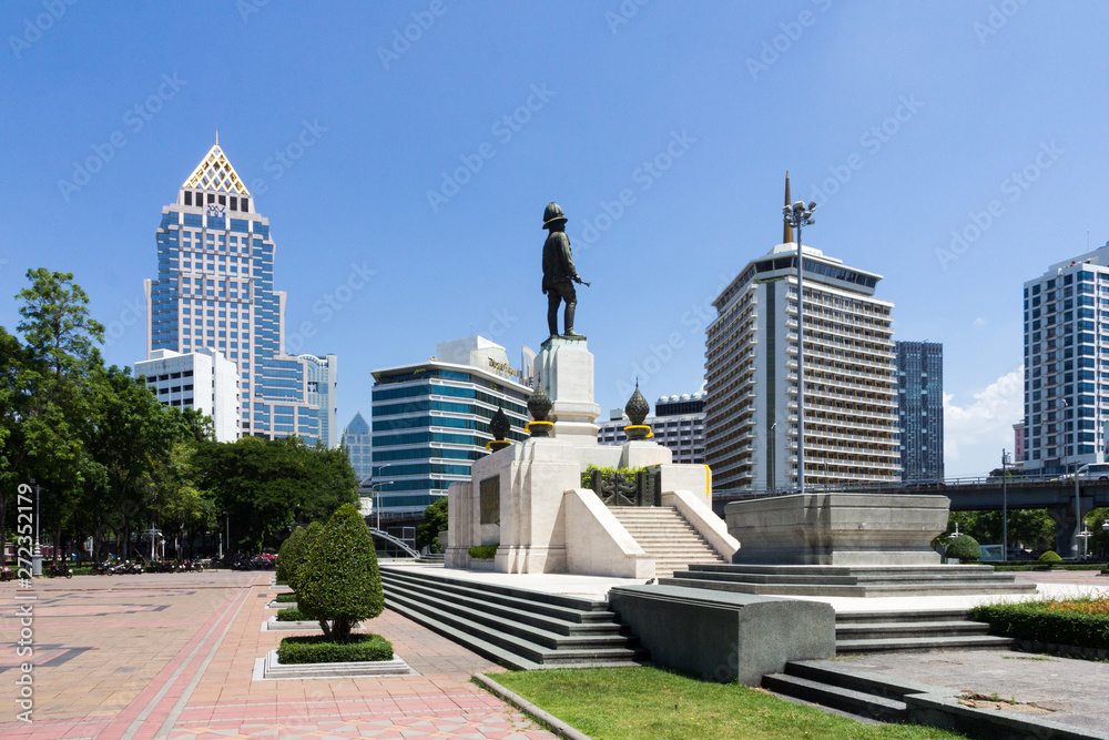 Statue of King Rama VI at the entrance to Lumphini park with office and ...