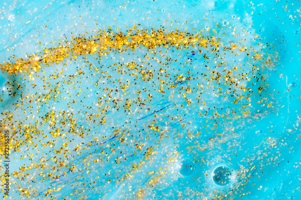 Abstract textured background blue slime with golden glitter particles ...