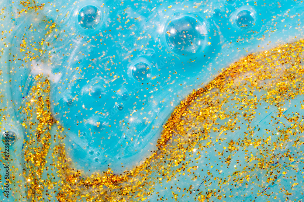 Abstract textured background blue slime with golden glitter particles ...