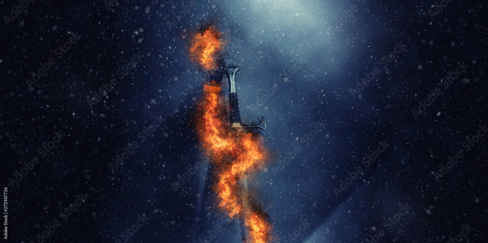 mysterious and magical photo of silver sword with fire flames over ...