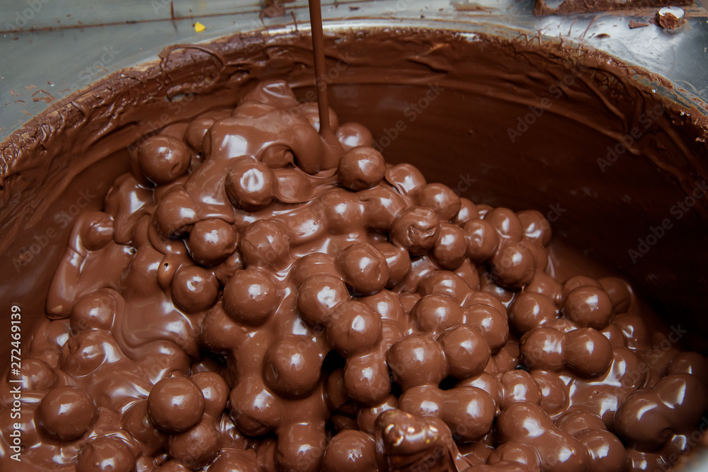 Production of chocolates in the factory. Milk chocolate in a large ...