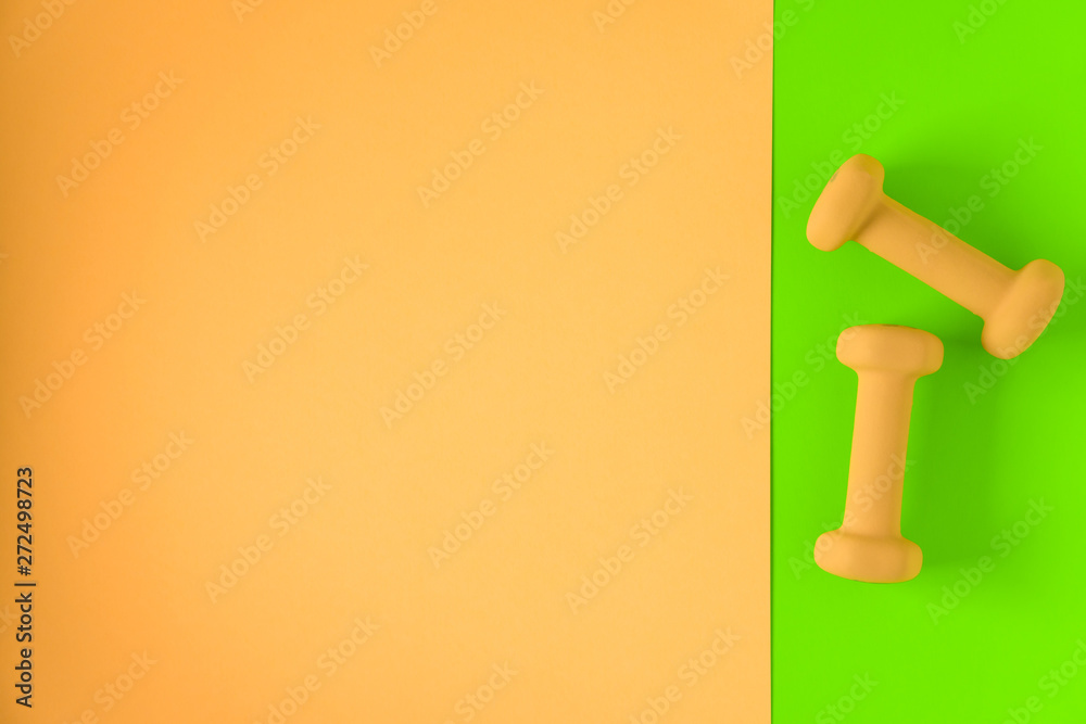 Fitness equipment with womens yellow weights/ dumbbells isolated on a ...