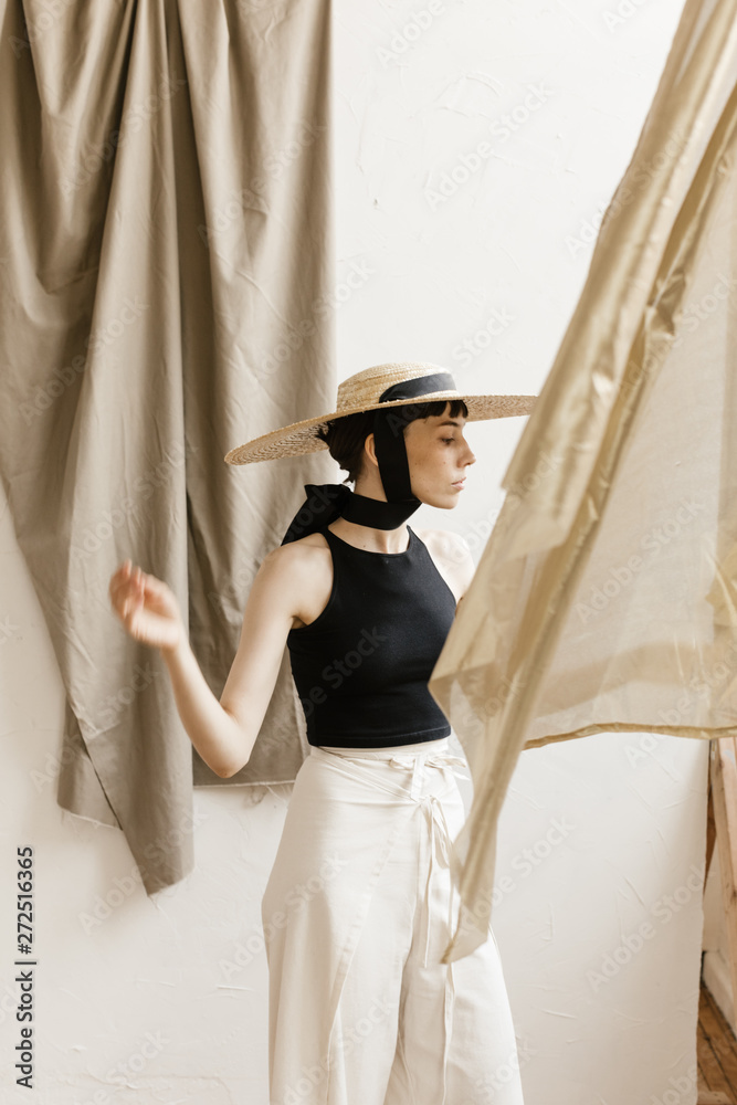 fashion model standing in studio scene with layered fabrics draped and ...